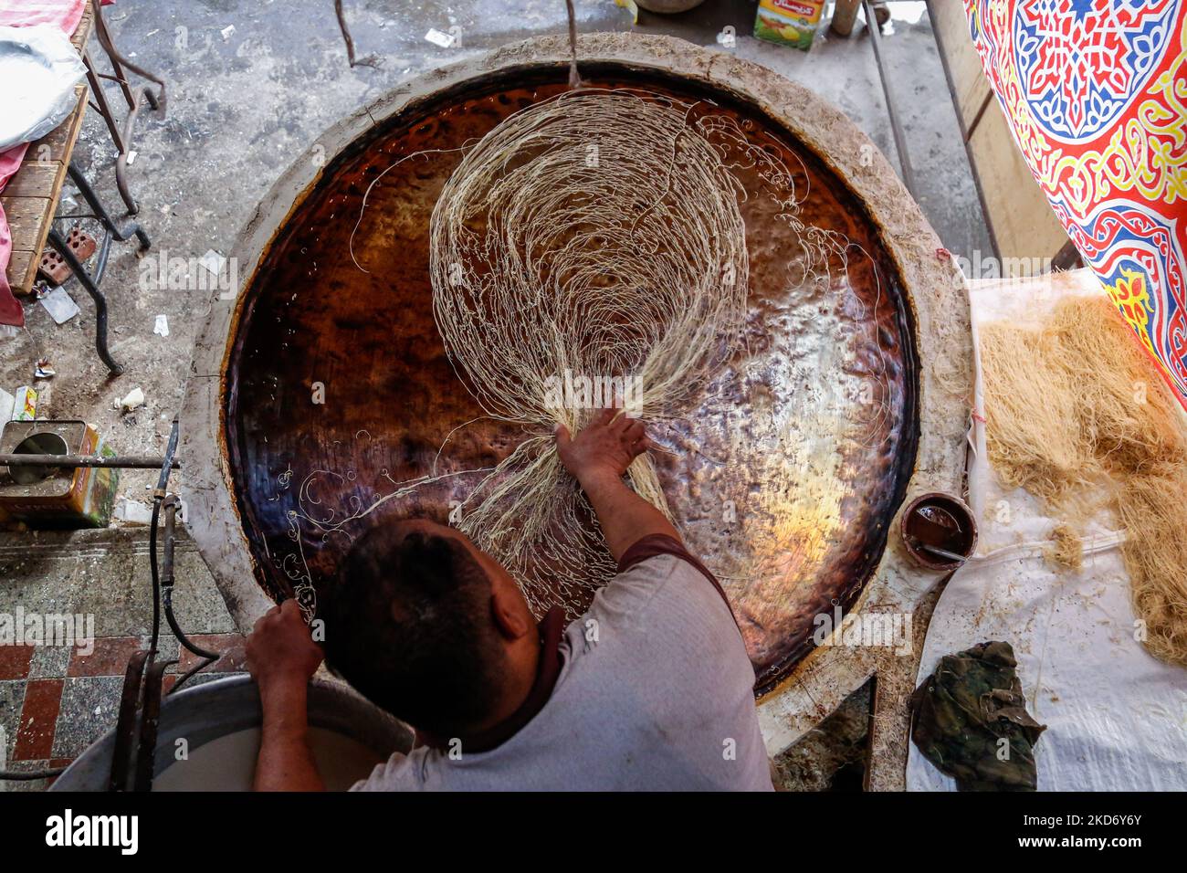 An Egyptian baker prepares 'Kanafeh', a traditional Middle Eastern ...