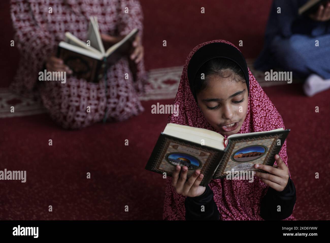 A Palestinian girl studies the holy Koran at a mosque during the Muslim ...