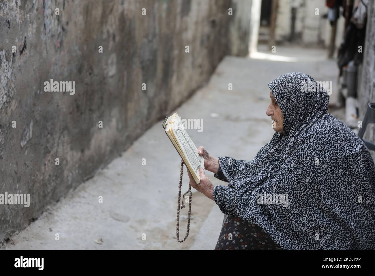 An elderly Palestinian woman reads the Quran during the month of ...