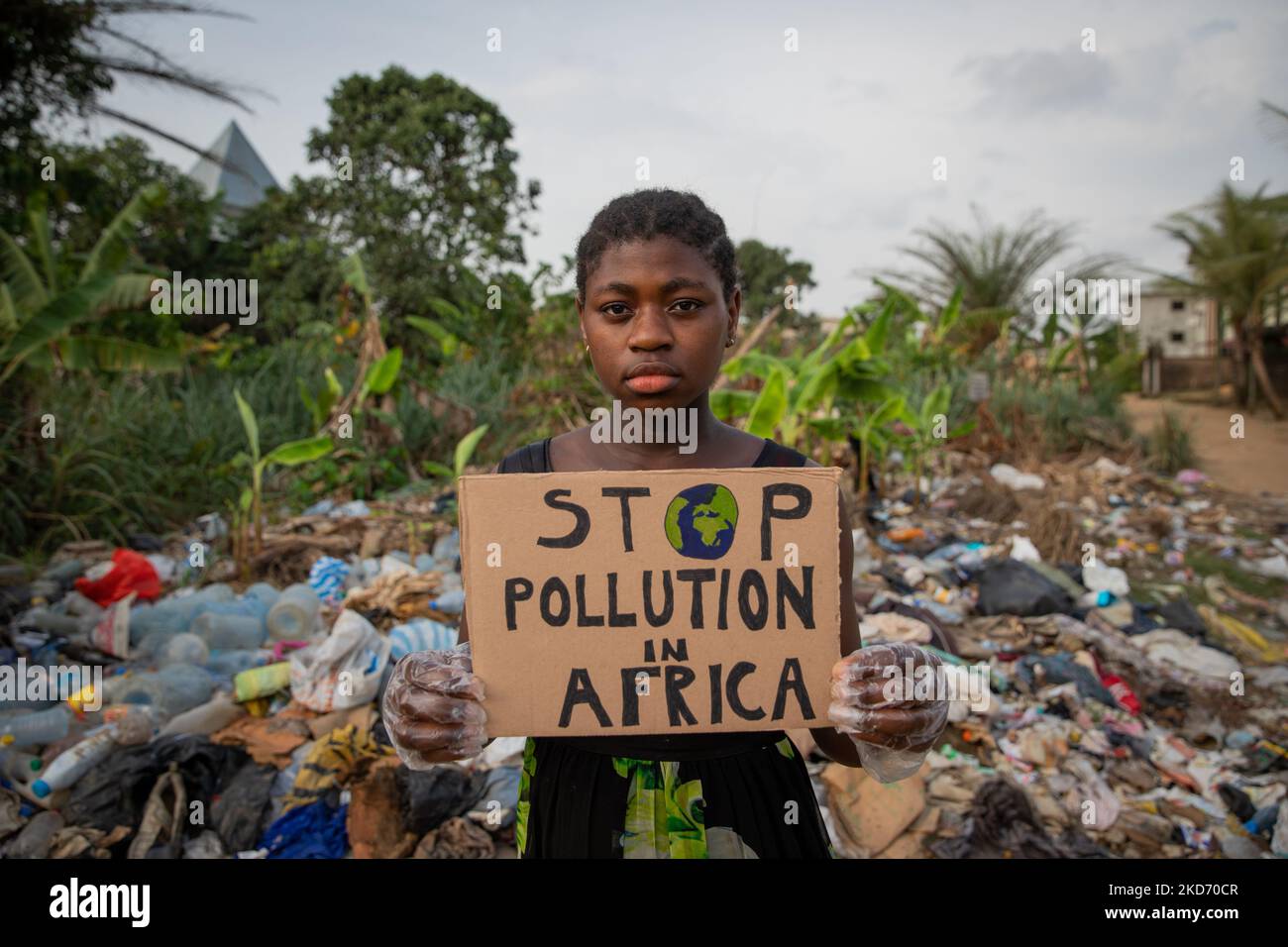Young black african girl holding a sign written: stop pollution in ...