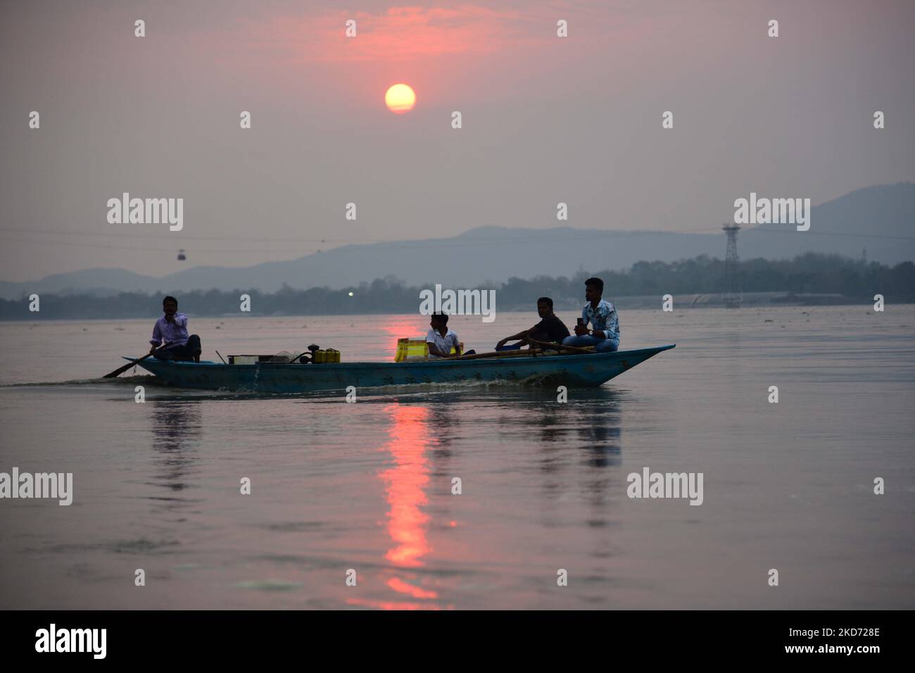 Fisherman row his boat in the Brahmaputra river at sunset in Guwahati ...