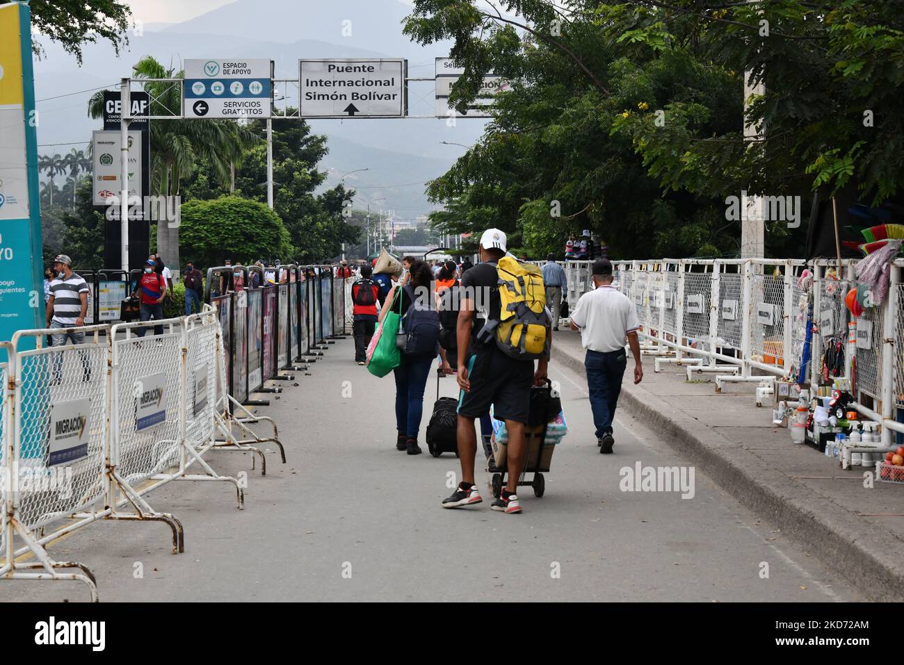 People pass through the migration zone of the bridge that joins the ...