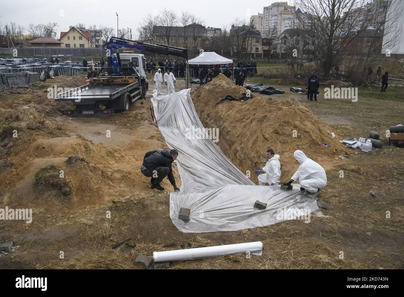 (EDITOR'S NOTE: Image depict deaths) Criminalists works with mass grave ...