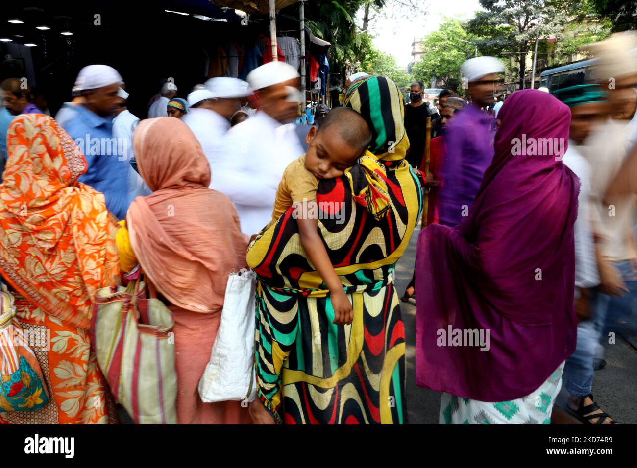 An Indian roadside women begger with his child begs for alms outside ...