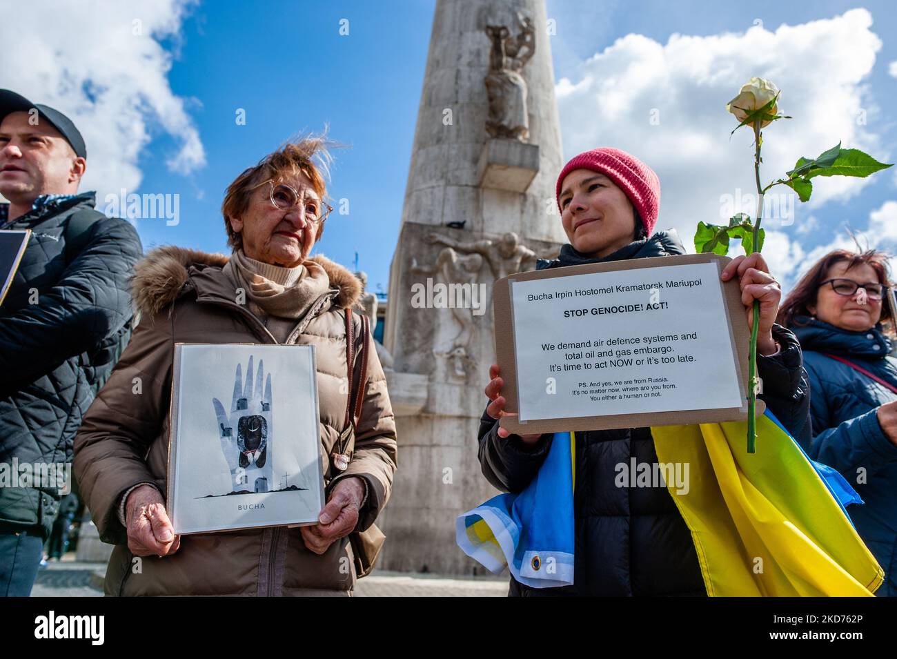 People are holding placards with the names of the Ukrainian cities ...