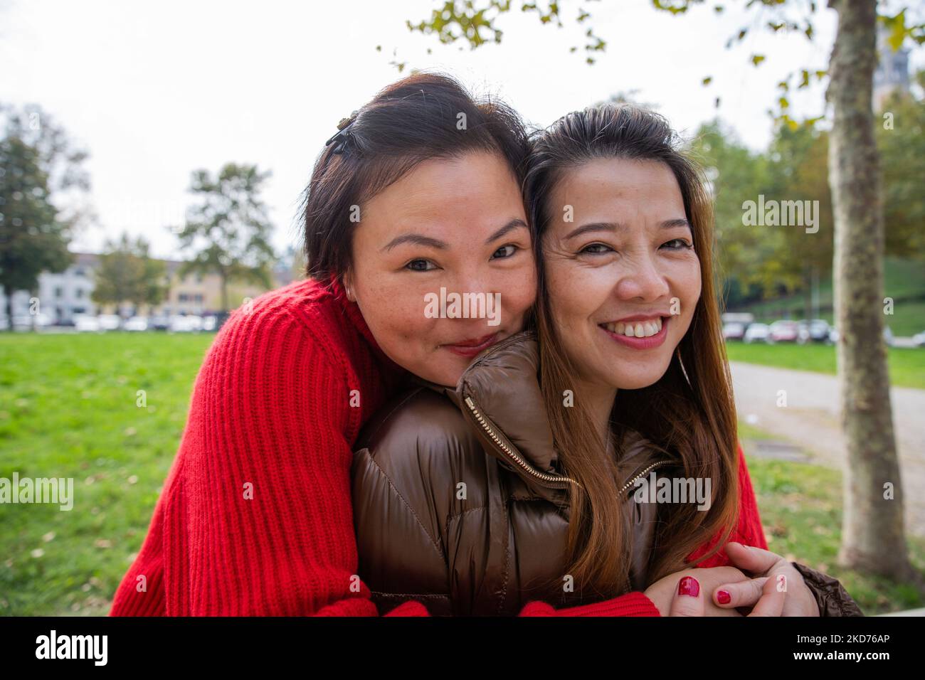Portrait of two attractive and cute chinese women smiling at the camera ...