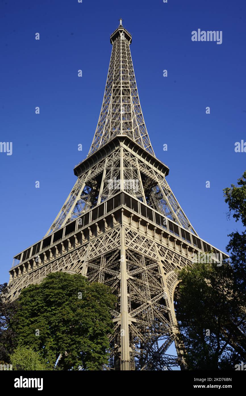 A low-angle shot of the Eiffel tower on the background of blue sky in ...