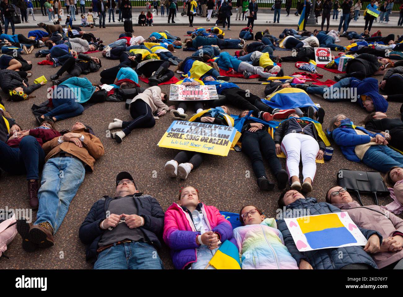 Protesters lie on the ground as they reenact the murder of 163 people ...
