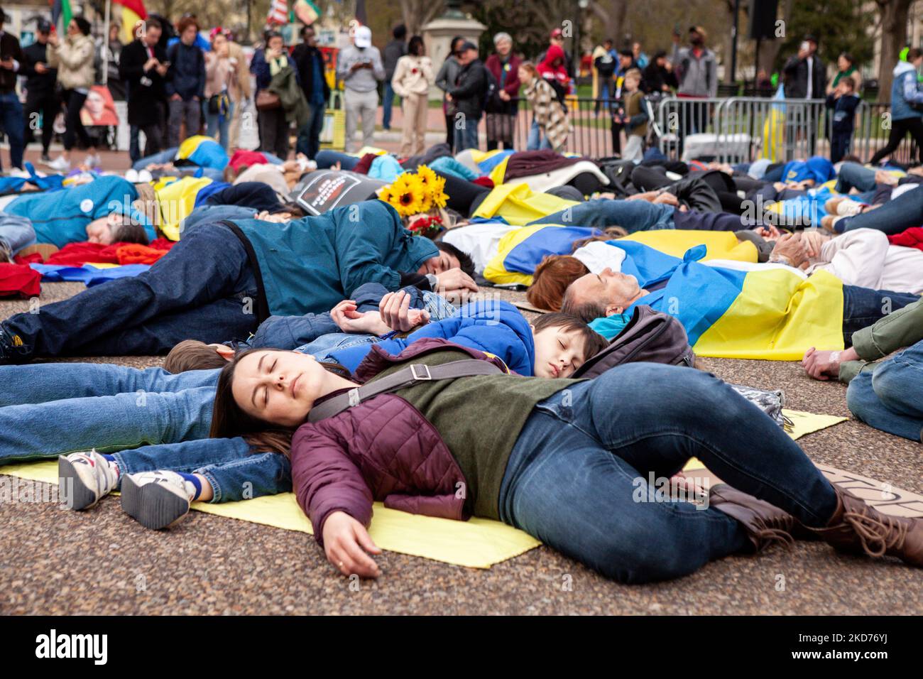 Protesters lie on the ground as they reenact the murder of 163 people ...