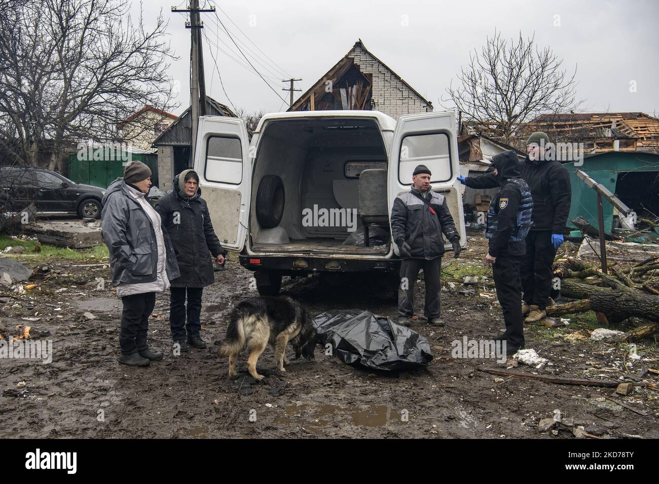 Relatives and neighbors stand next to a body of a person found under ...