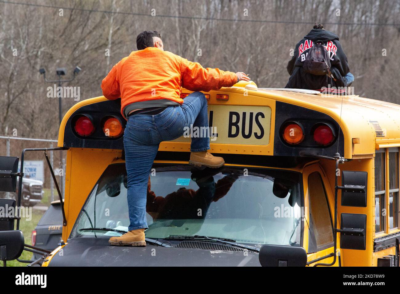 A demonstrator climbs on top of a school bus as climate activists ...