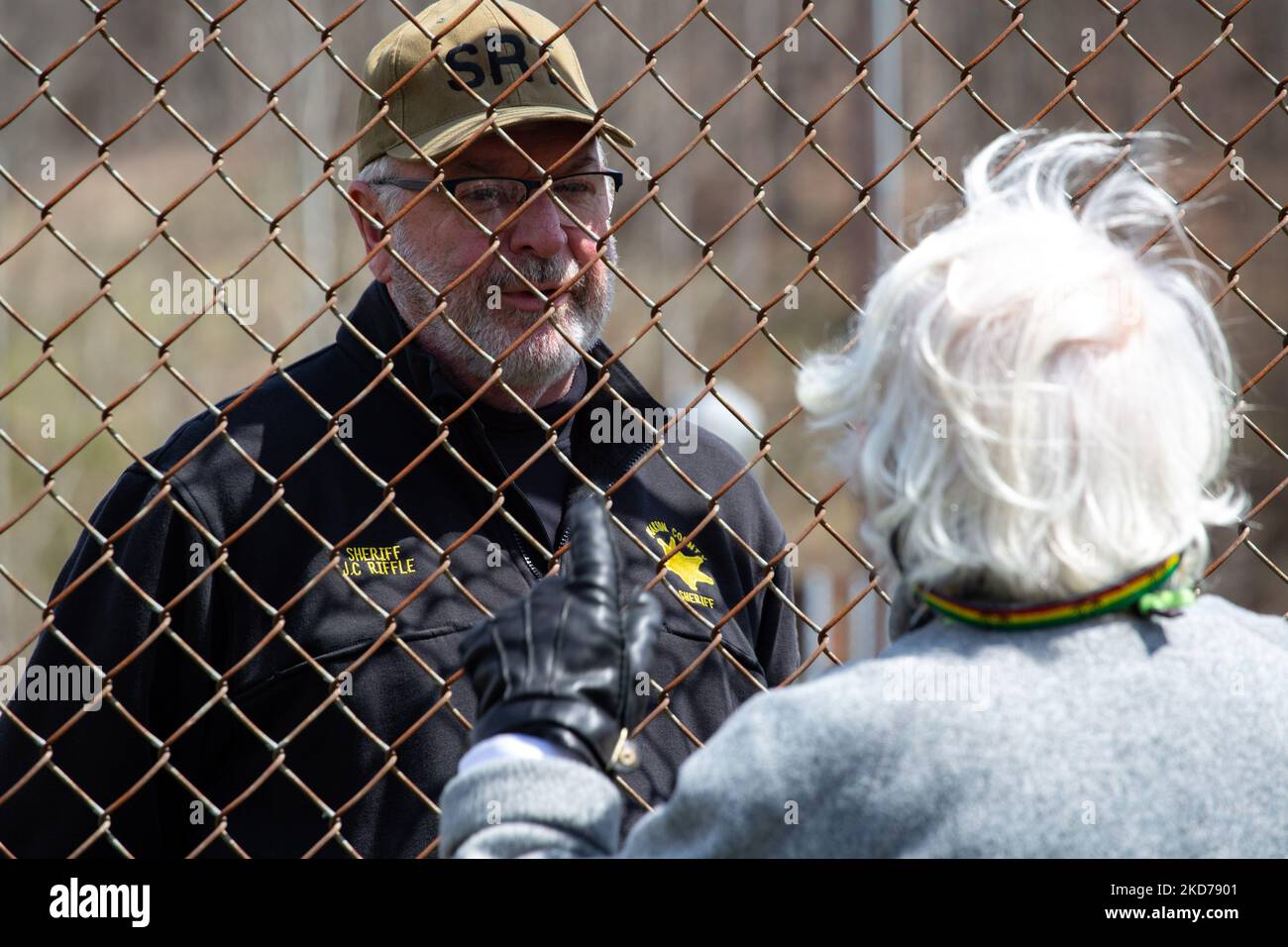 Police speak with climate activists gathered to block the entrance to ...