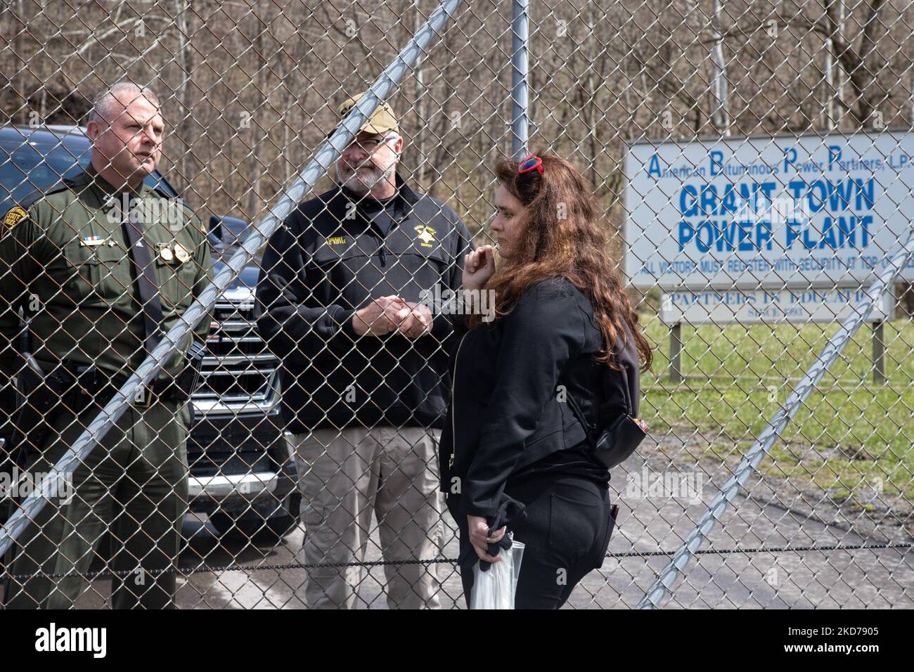 Police speak with climate activists gathered to block the entrance to ...