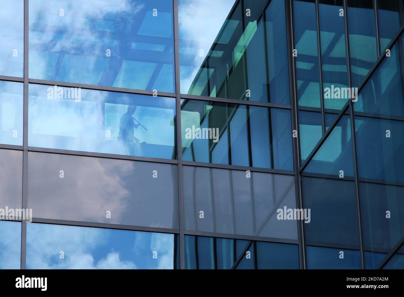 shadow of a window cleaner who cleans reflective glass pane Stock Photo ...
