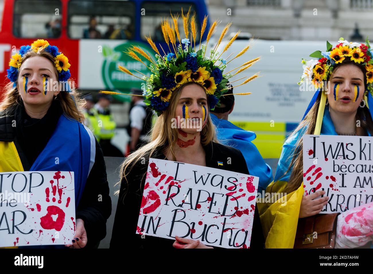 People hold placards and blood splattered fake-babies at a protest in ...