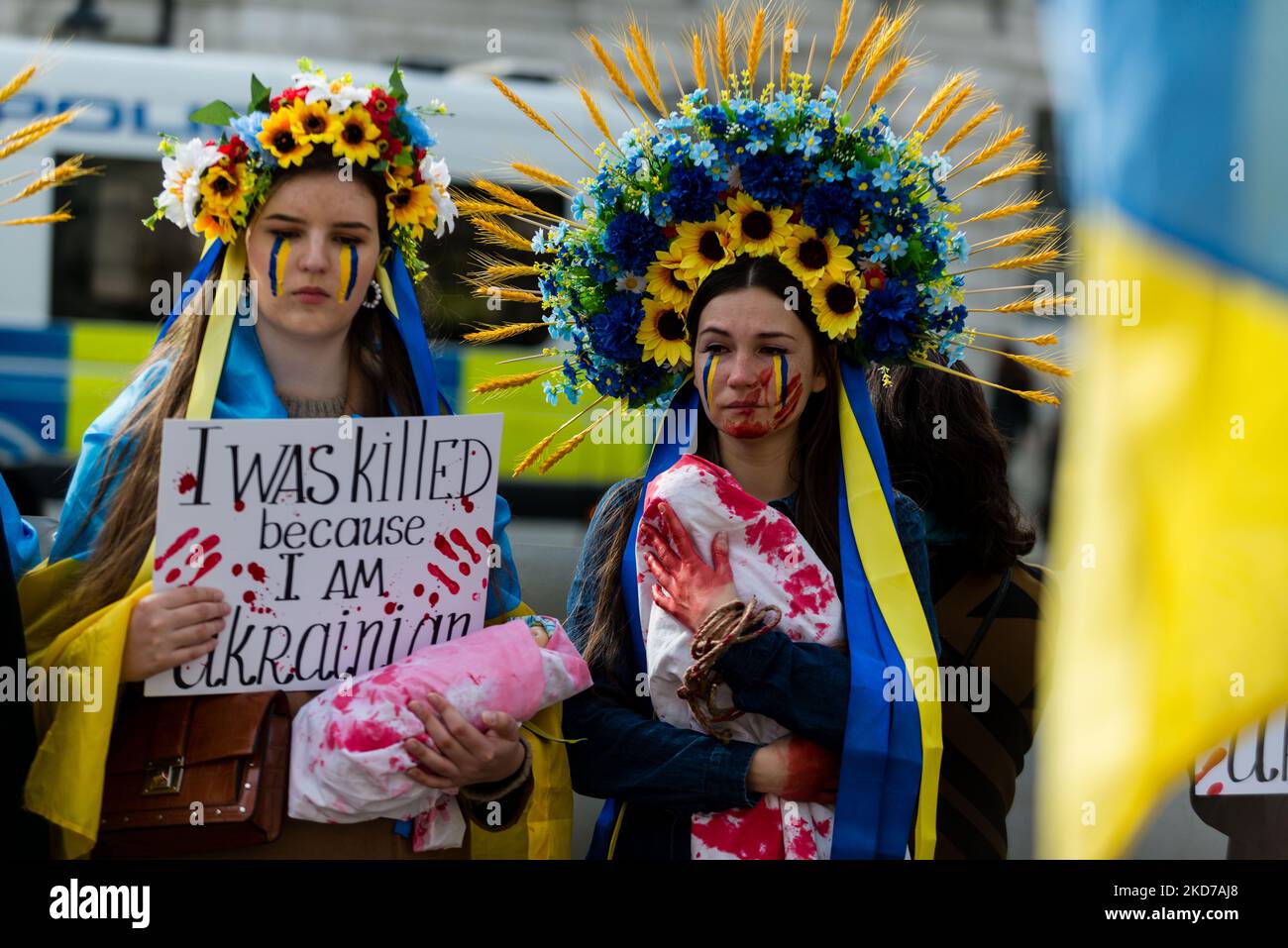 People hold placards and blood splattered fake-babies at a protest in ...