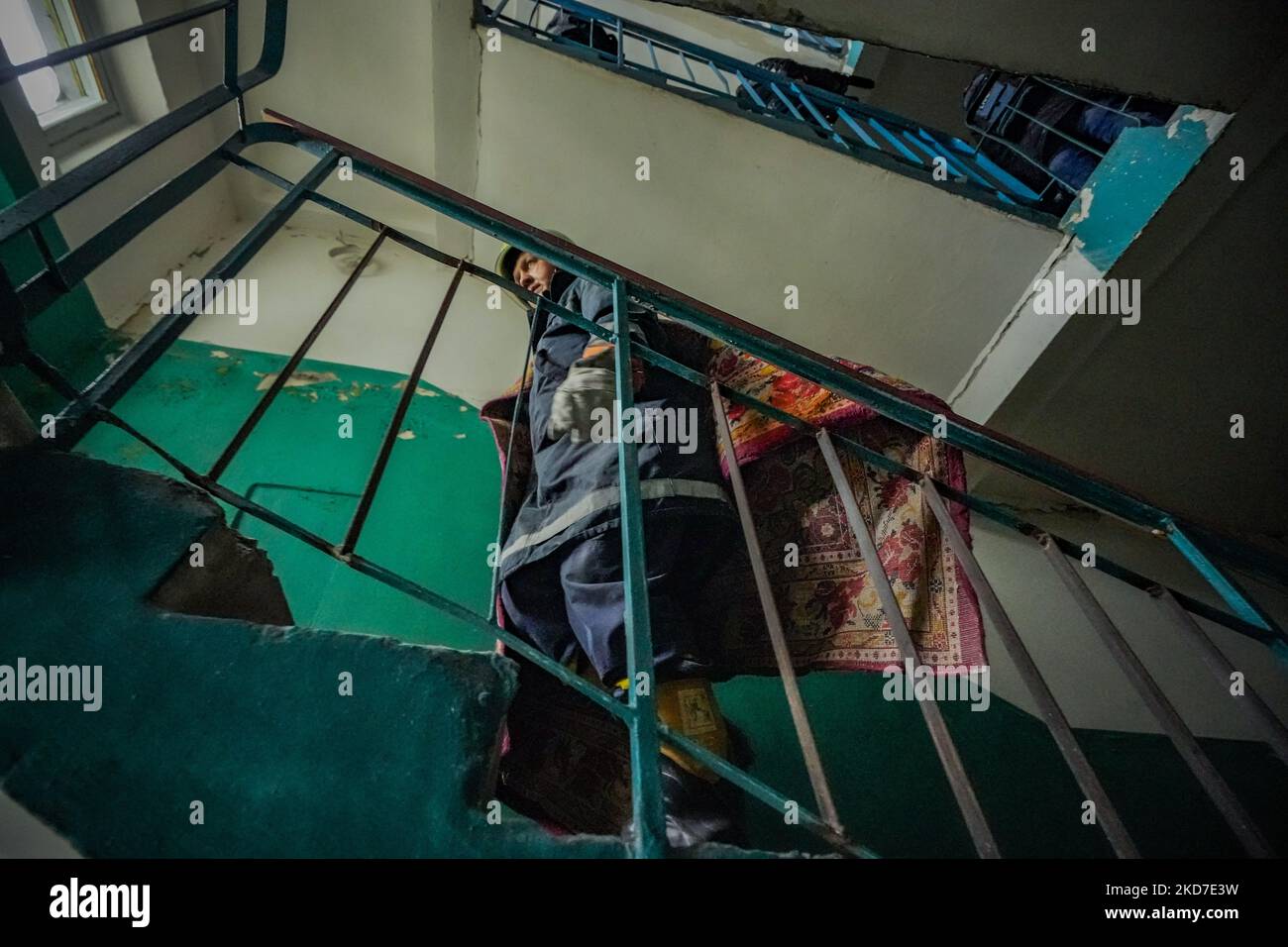 A rescuer carries a carpet to cover the corpse of a dead woman founded ...