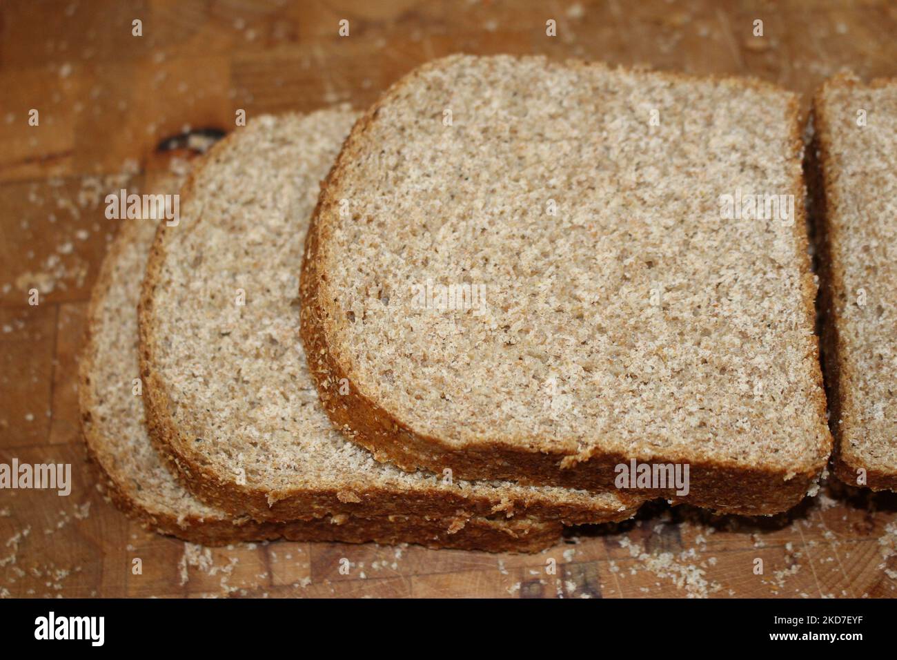 Three stacked slices of bread on a wooden cutting board - freshly baked ...