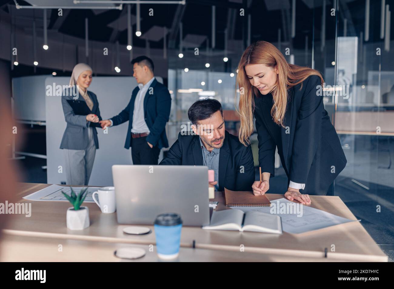 Two smiling coworkers working together analyzing the charts in office ...