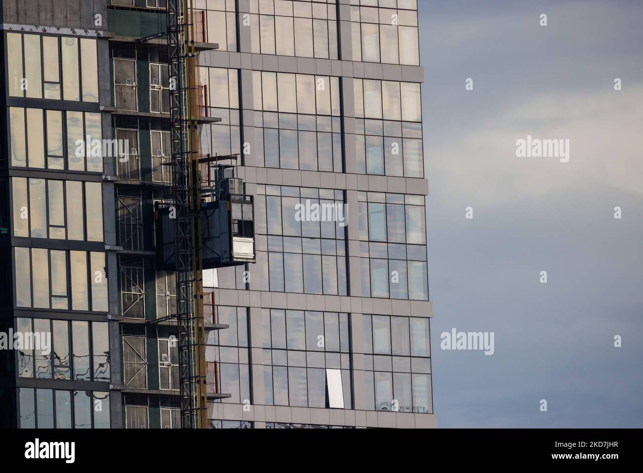 A construction elevator on the side of a high rise building Stock Photo ...