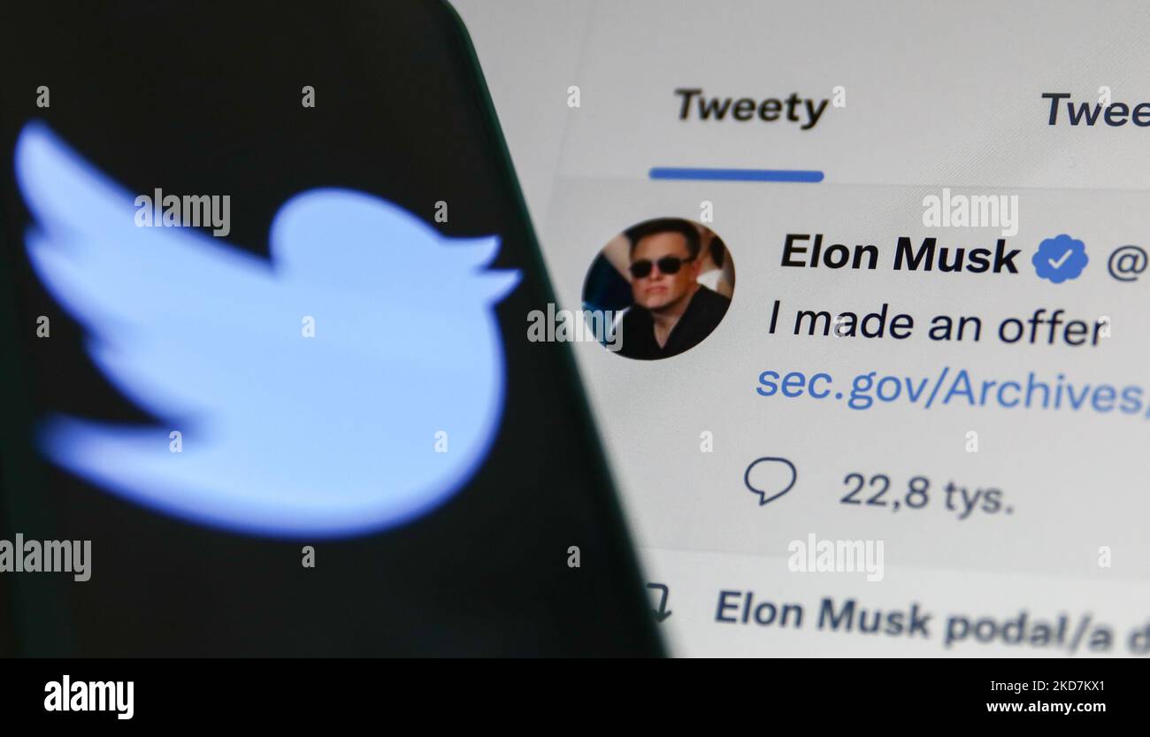 Elon Musk's Tweet displayed on a screen and Twitter logo displayed on a ...