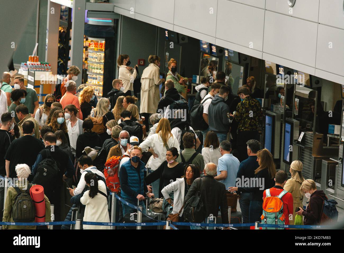 Travllers queue at Condor check in counter at Duesseldorf airport ahead ...