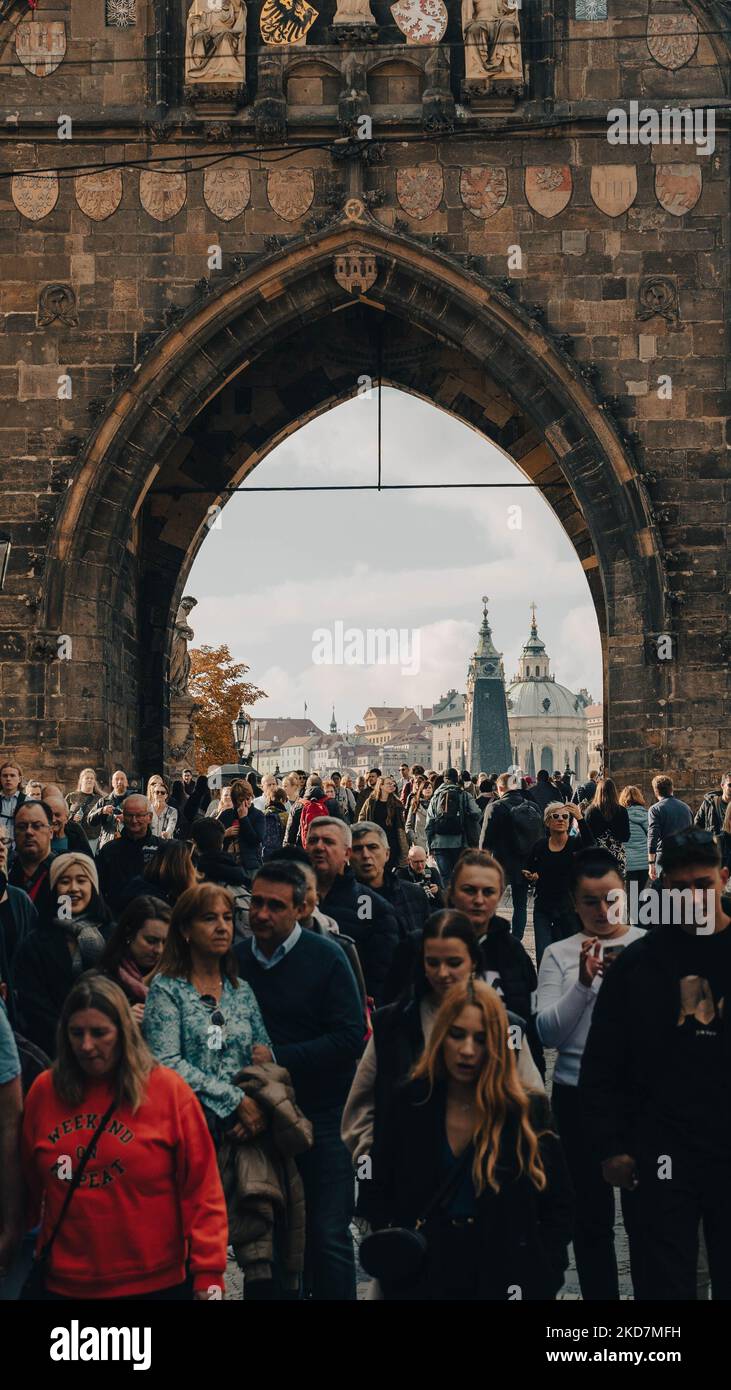 A vertical shot of people walking in the street at the arched gate with ...