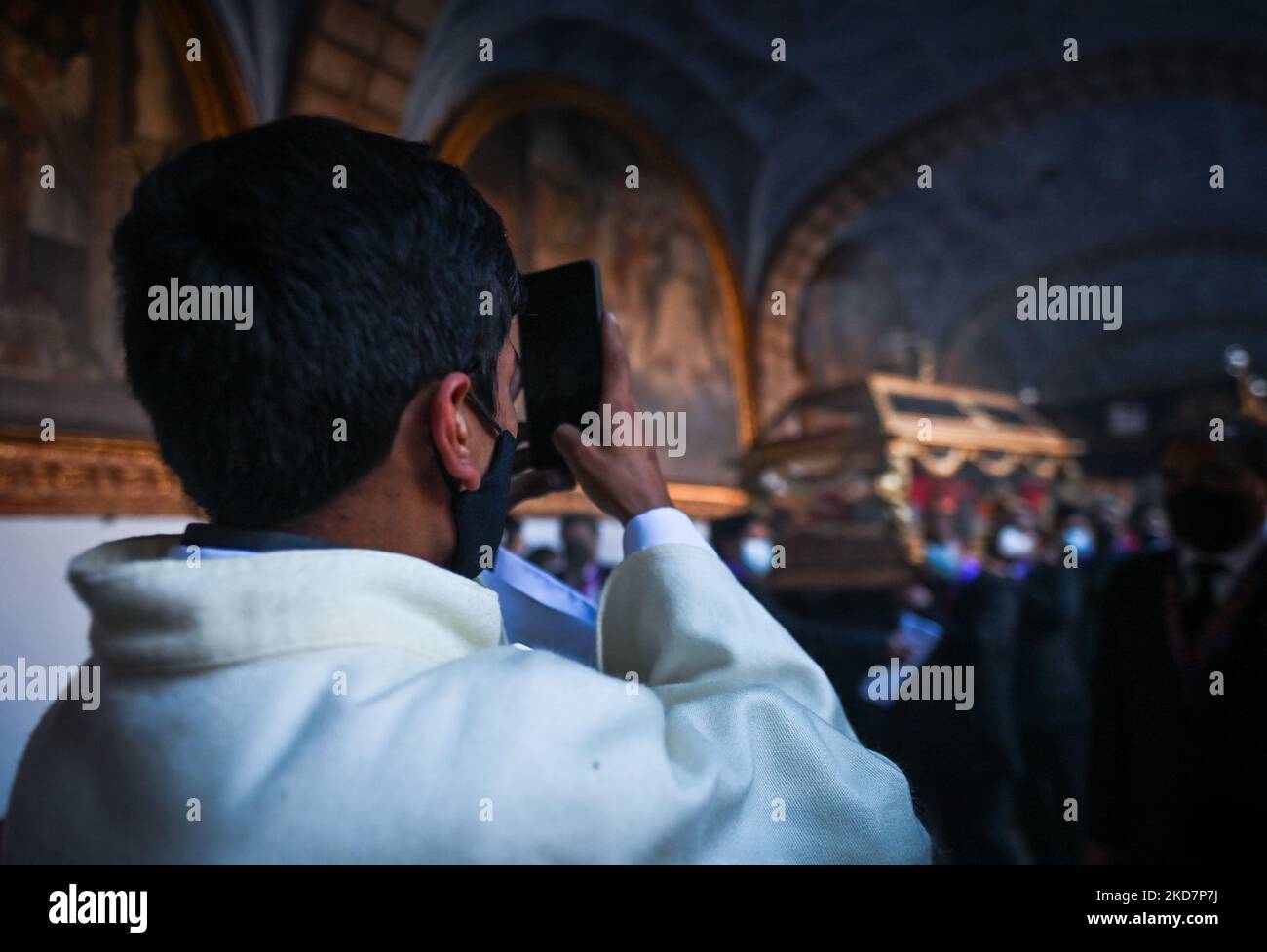 A priest takes a photo with his mobile phone of the procession with the ...