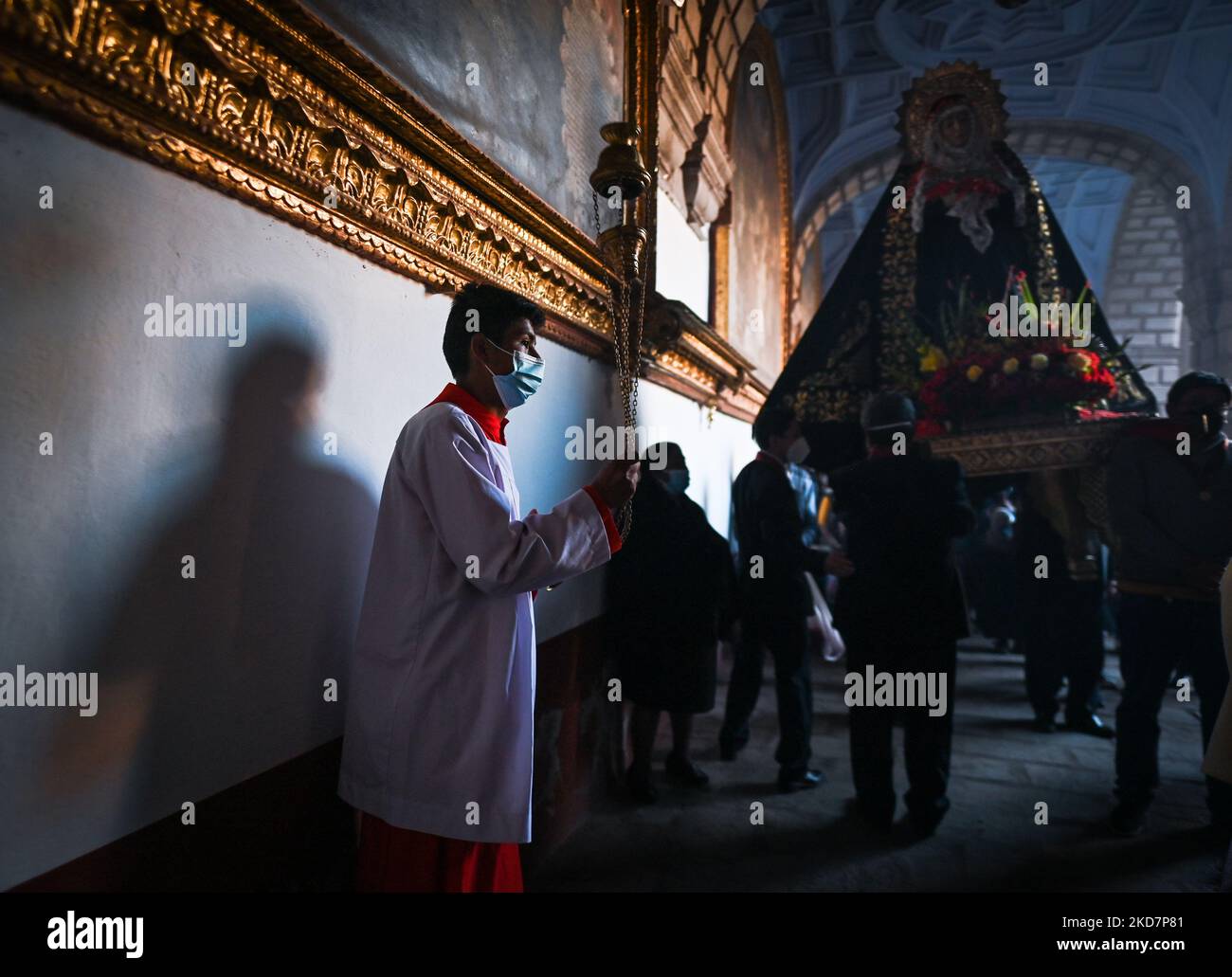 An altar boy swings a censer burning incense to clear the way while ...