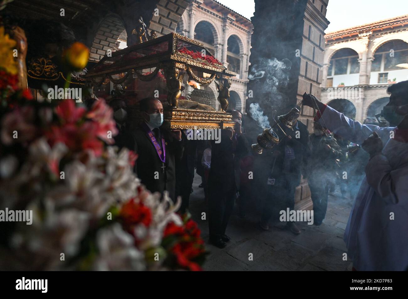 An altar boy swings a censer burning incense to clear the way while ...