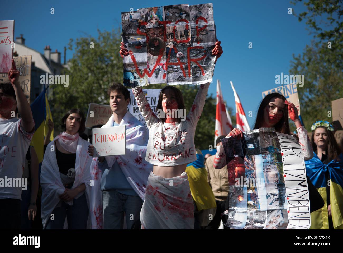 Demonstrators in red-stained clothes denounce the war in Ukraine at the ...