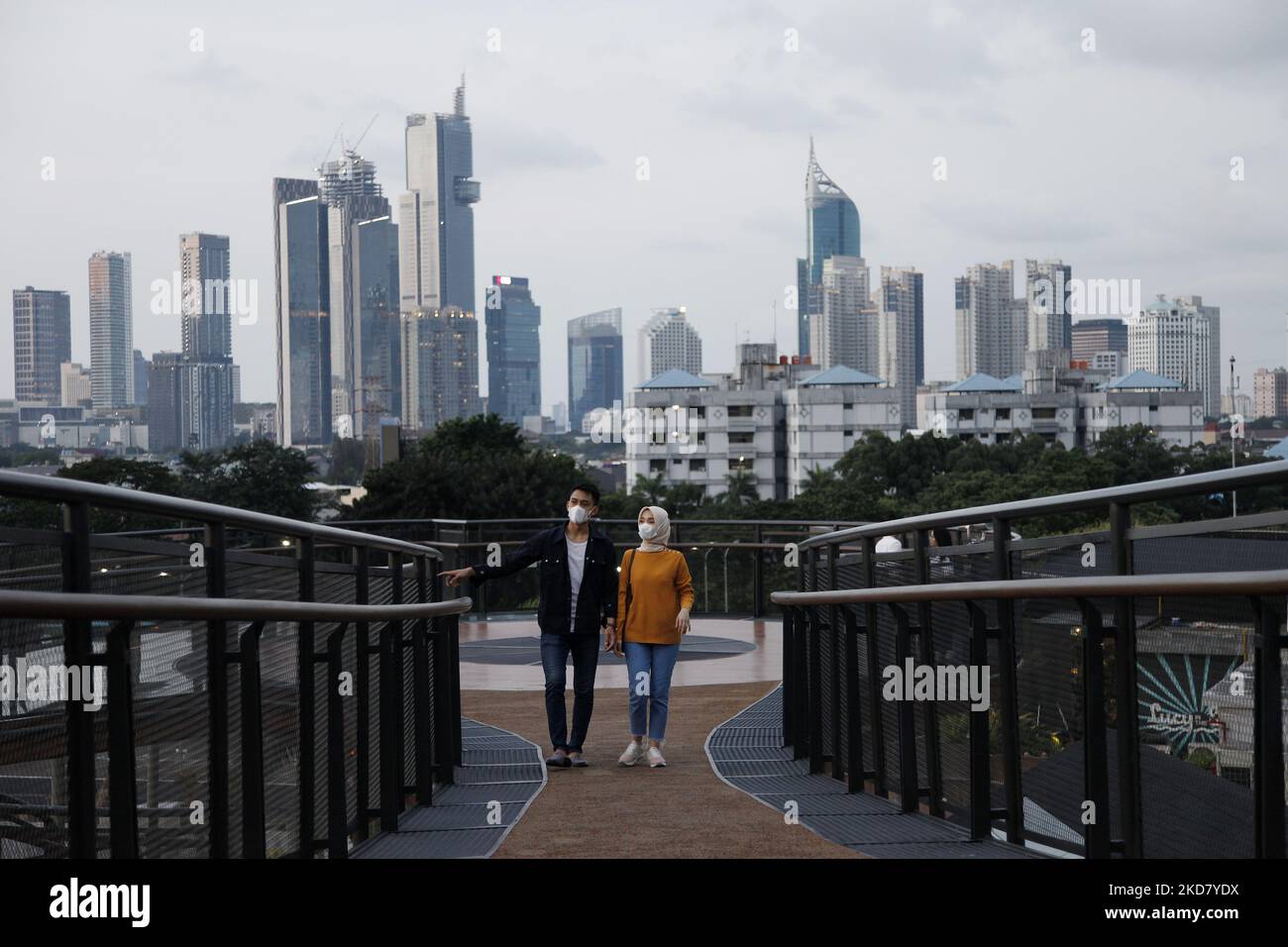 People enjoy Jakarta landscapes from the Senayan Skywalk bridge in Jakarta, on April 18, 2022 ...