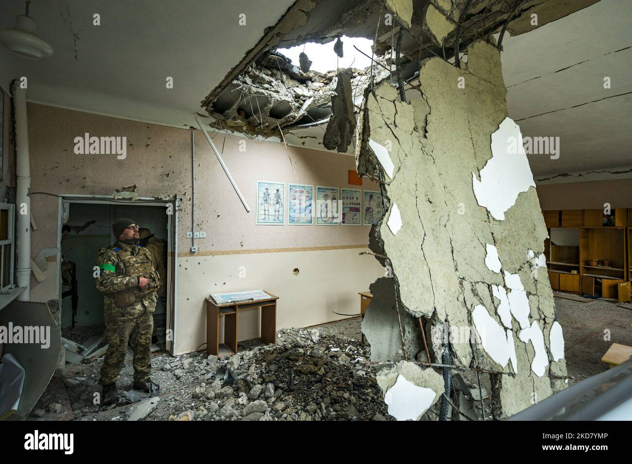 A ukrainian soldier looks the aftermath of a russian shelling over a ...
