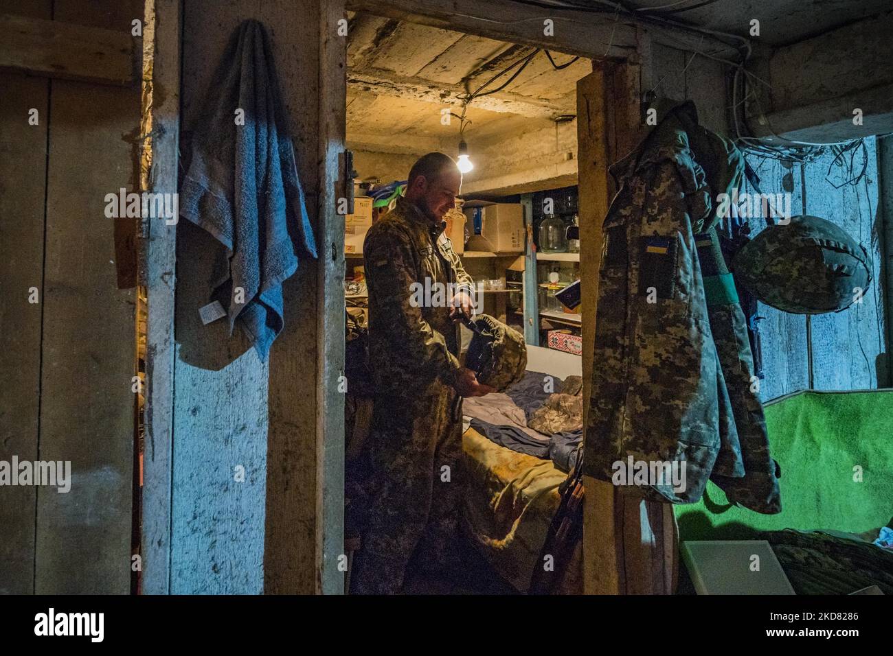 Ukrainian soldier prepares his equipment before a guard shift in a ...