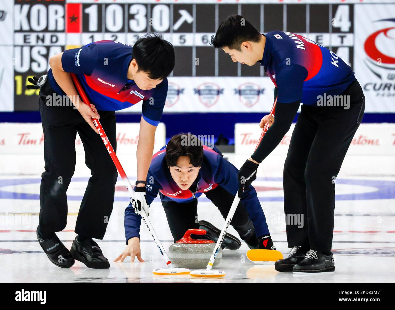 Korea skip Jeong Byeong-jin, centre, makes a shot as lead Kim Tae-hwan ...
