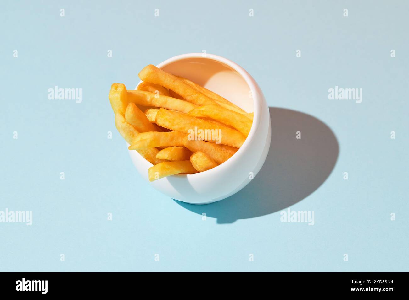 Fresh tasty french fries in plate on blue background. Trendy deep long ...