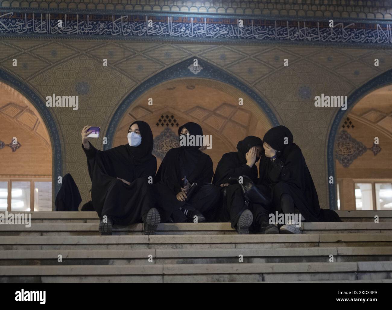A group of Iranian young women wearing protective face masks take a ...