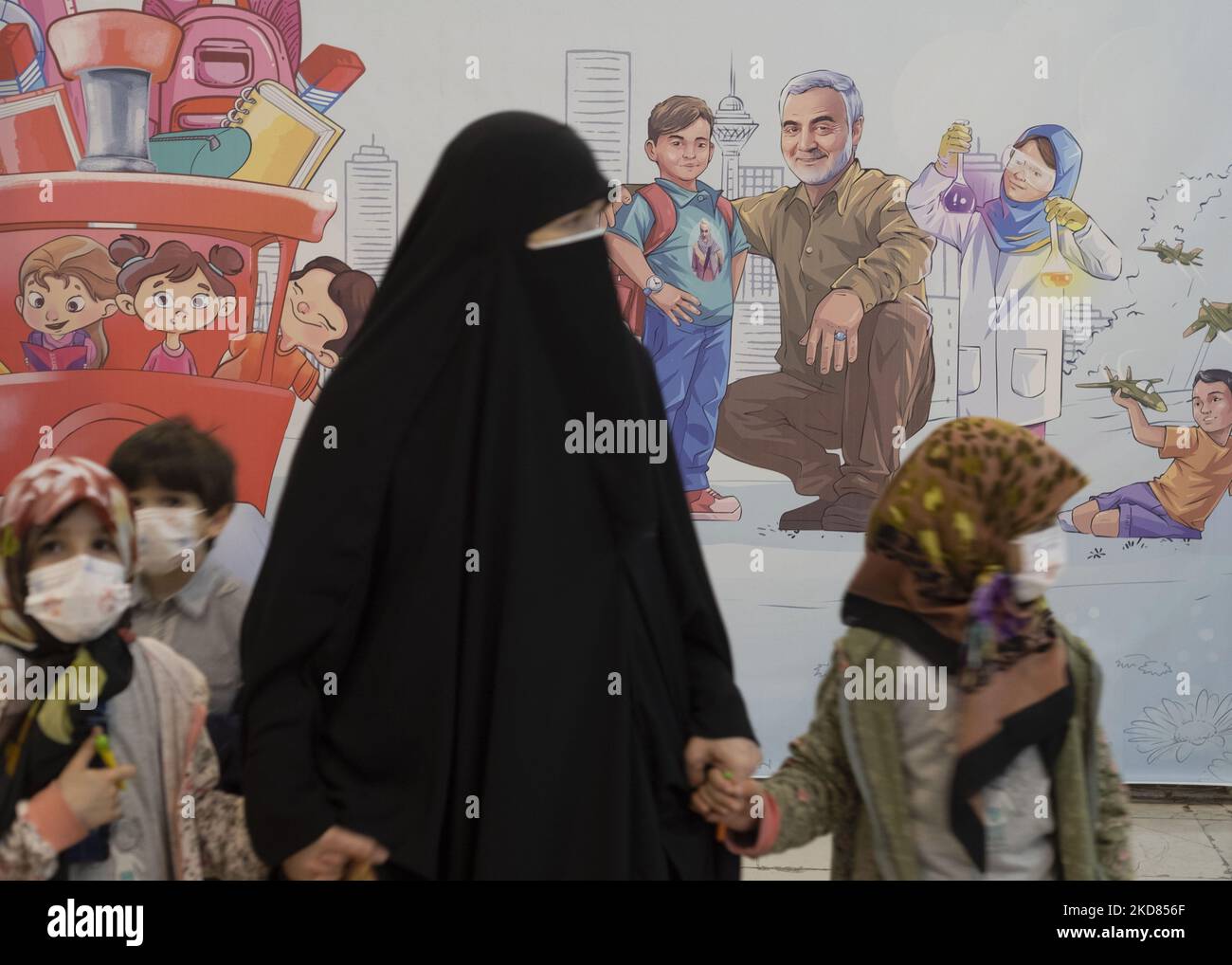 An Iranian veiled woman and her young daughters wearing protective face ...