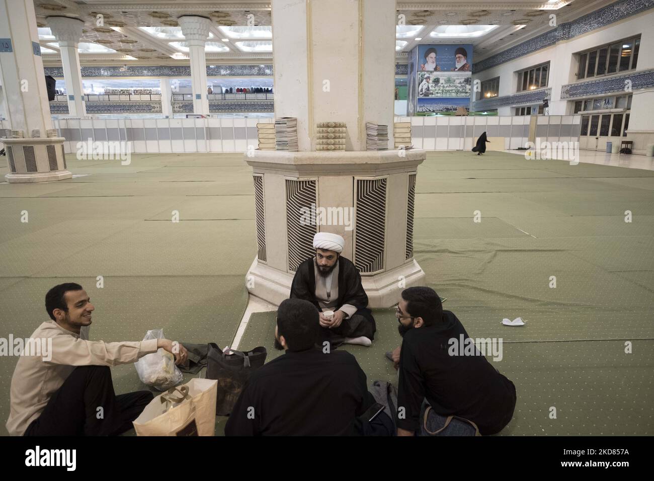 A group of Iranian clerics talk to each other as they sit at a prayer ...