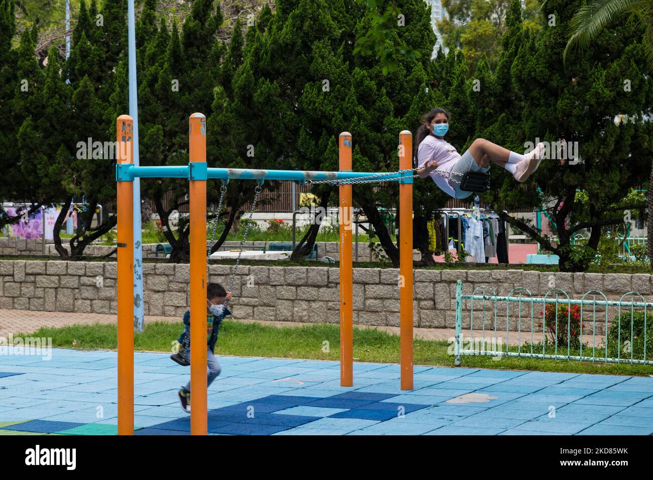 Two children enjoy a swing in a just reopened playground in Kai Yip ...