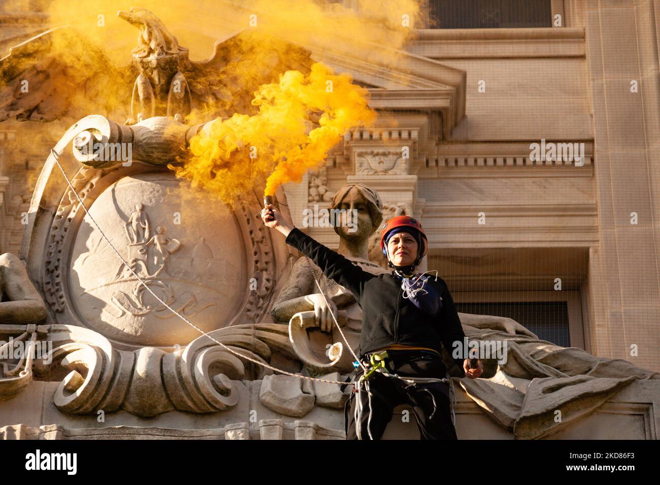 A member of Extinction Rebellion releases orange smoke after dropping a ...