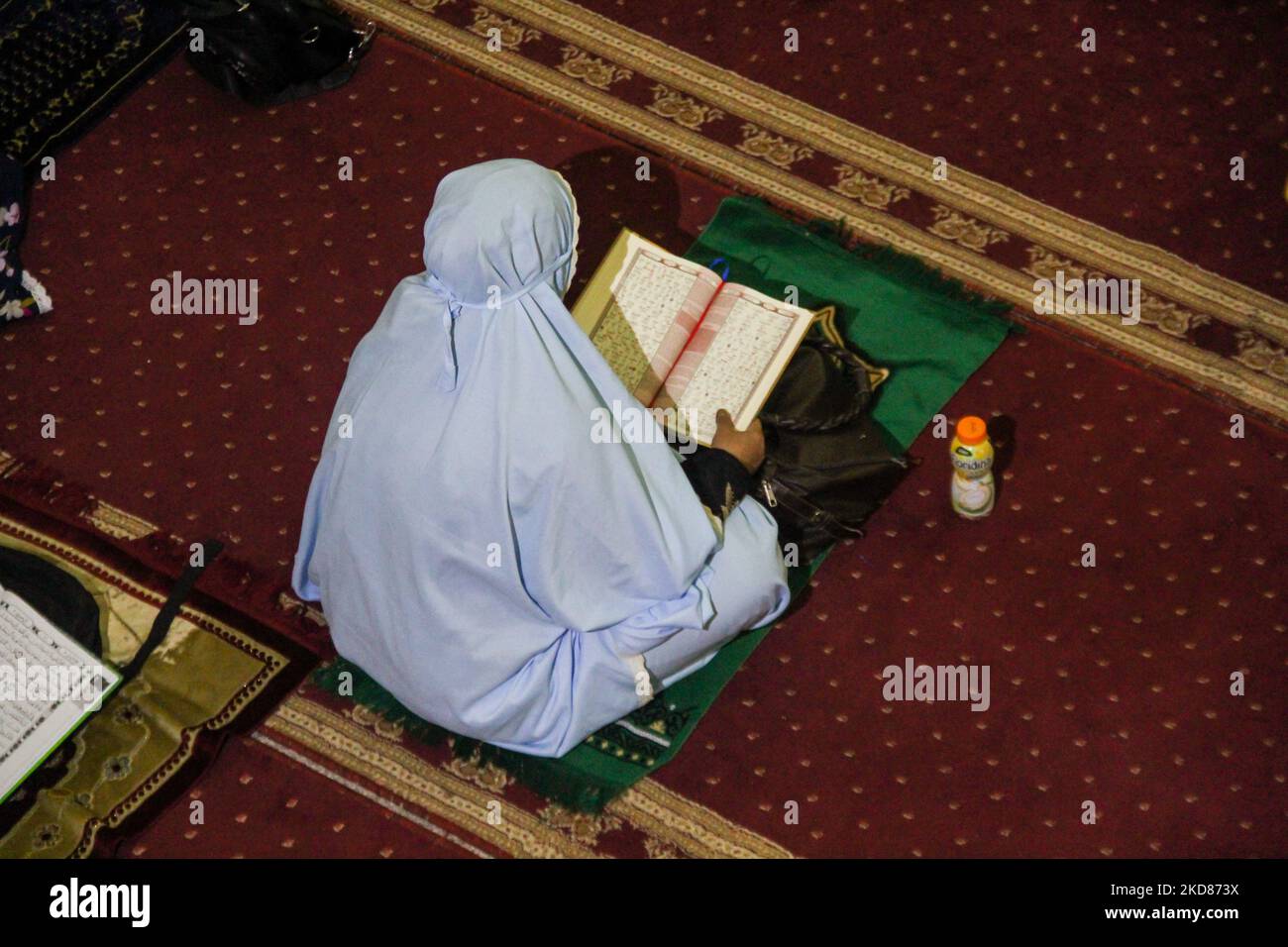 Muslims read the Quran during I'tikaf (staying in a mosque to pray) to ...
