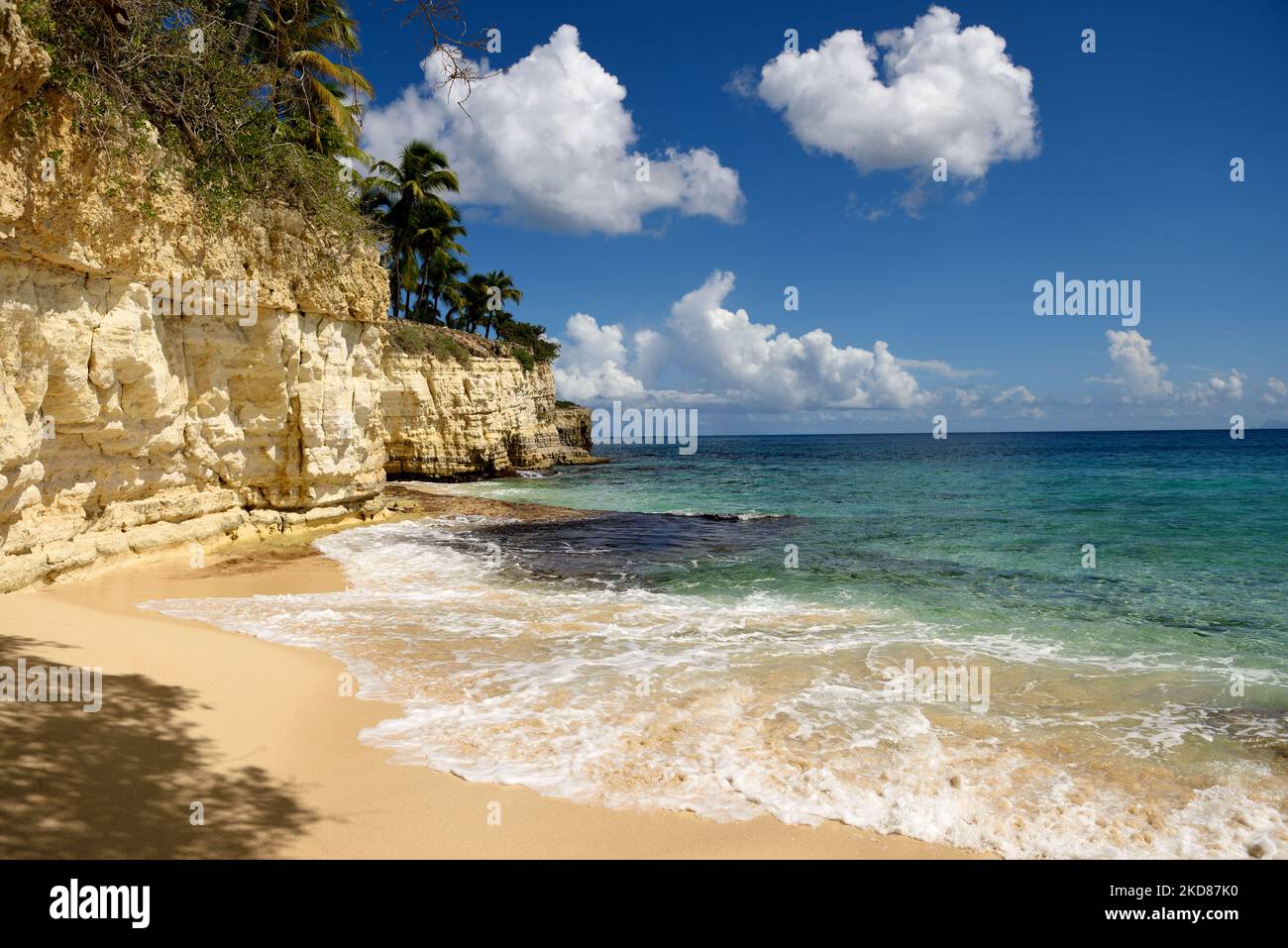 Secluded, hidden tranquil beach with sea cliffs, blue water, sky and ...