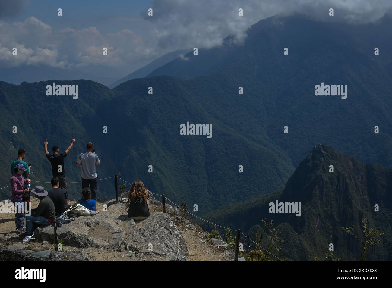 Tourists enjoy a view of of the ancient Inca city of Machu Picchu ...