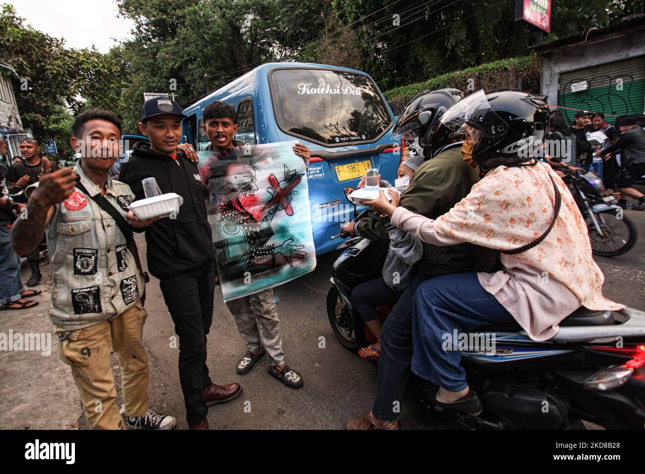 Indonesian street musicians in punk outfits distribute food boxes of ...