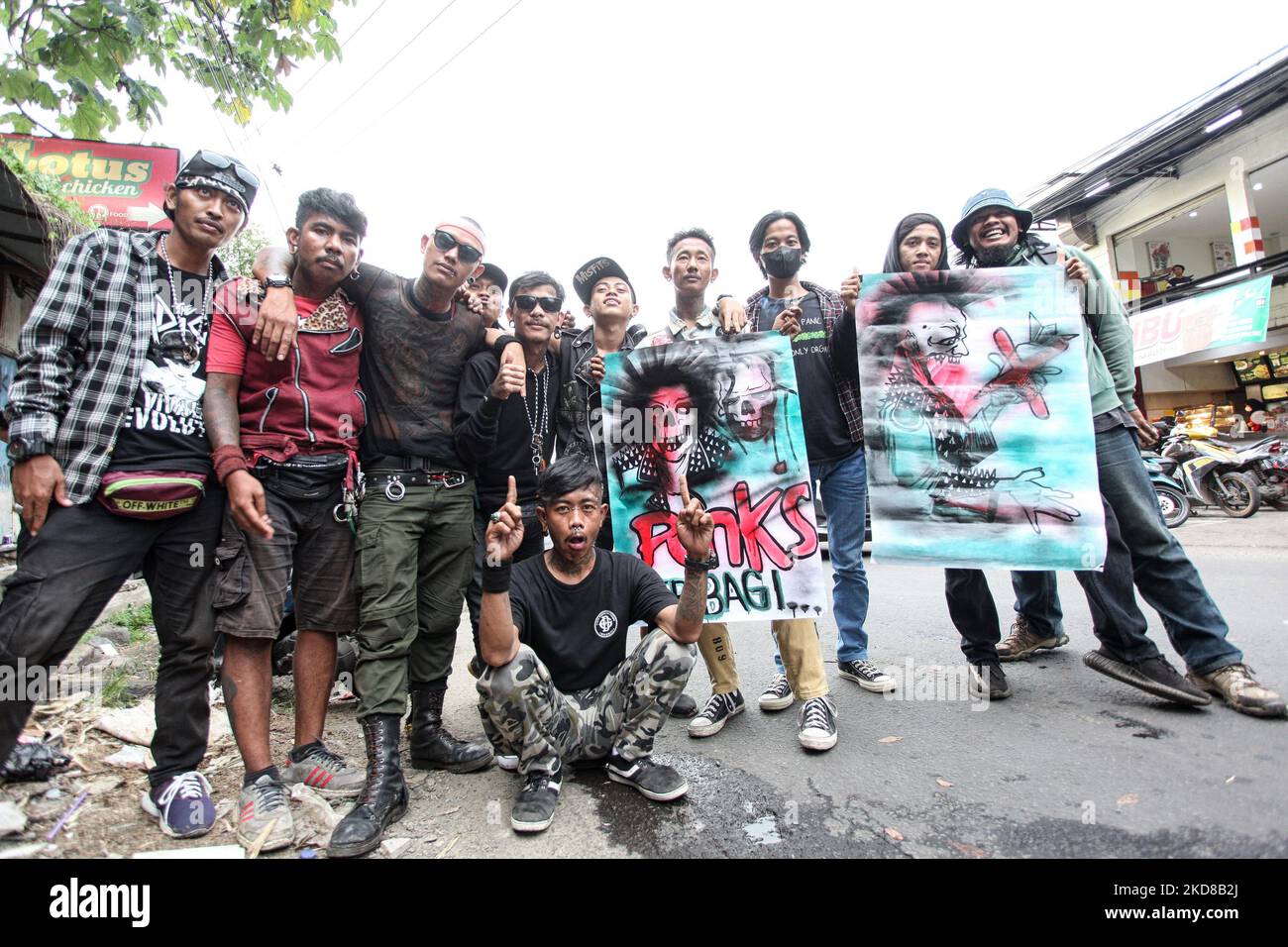 Indonesian street musicians in punk outfits pose during distribute food ...