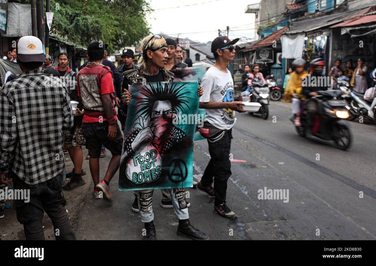 An Indonesian street musicians in punk outfits distribute food boxes of ...