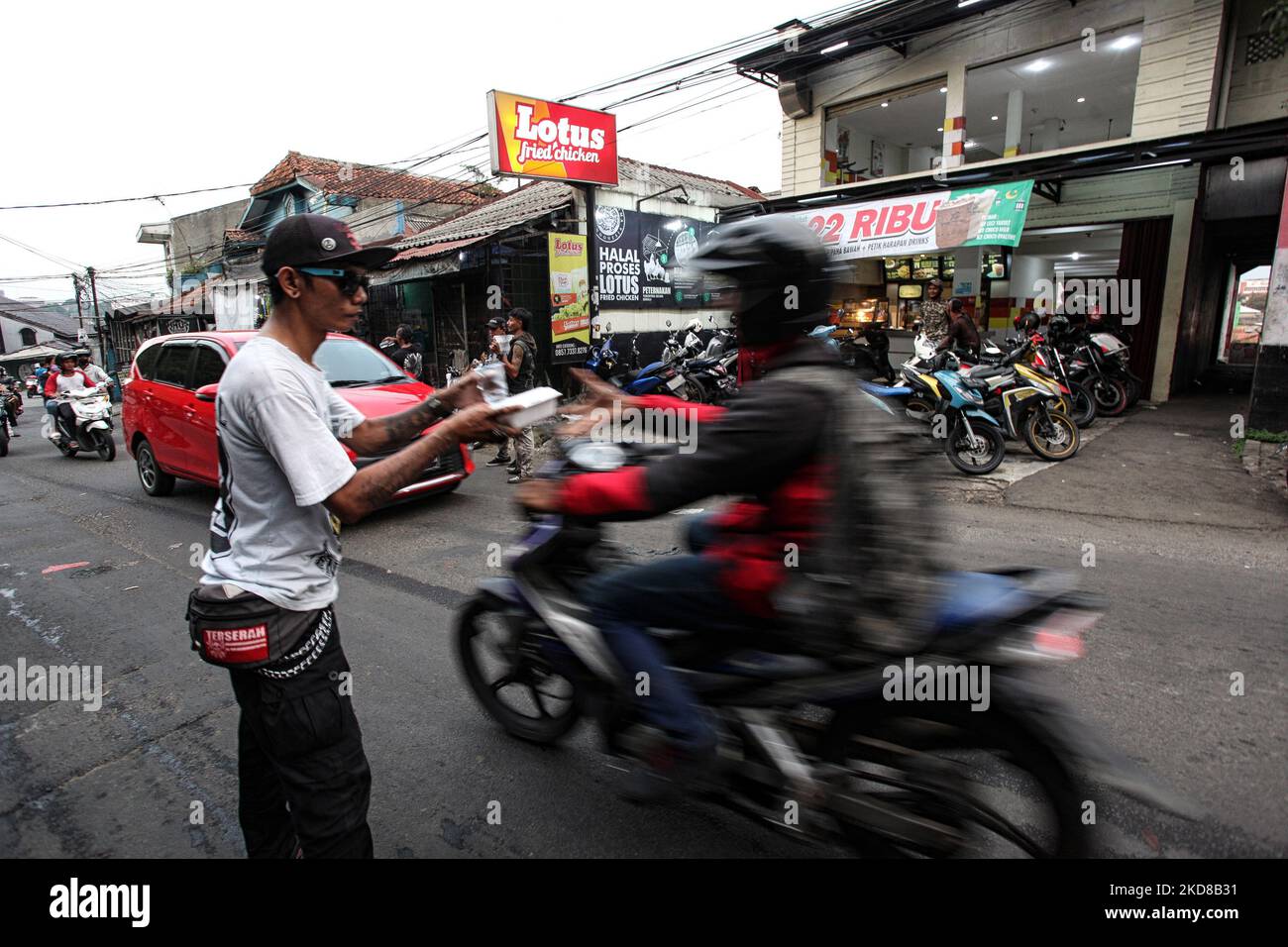 An Indonesian street musicians in punk outfits distribute food boxes of ...