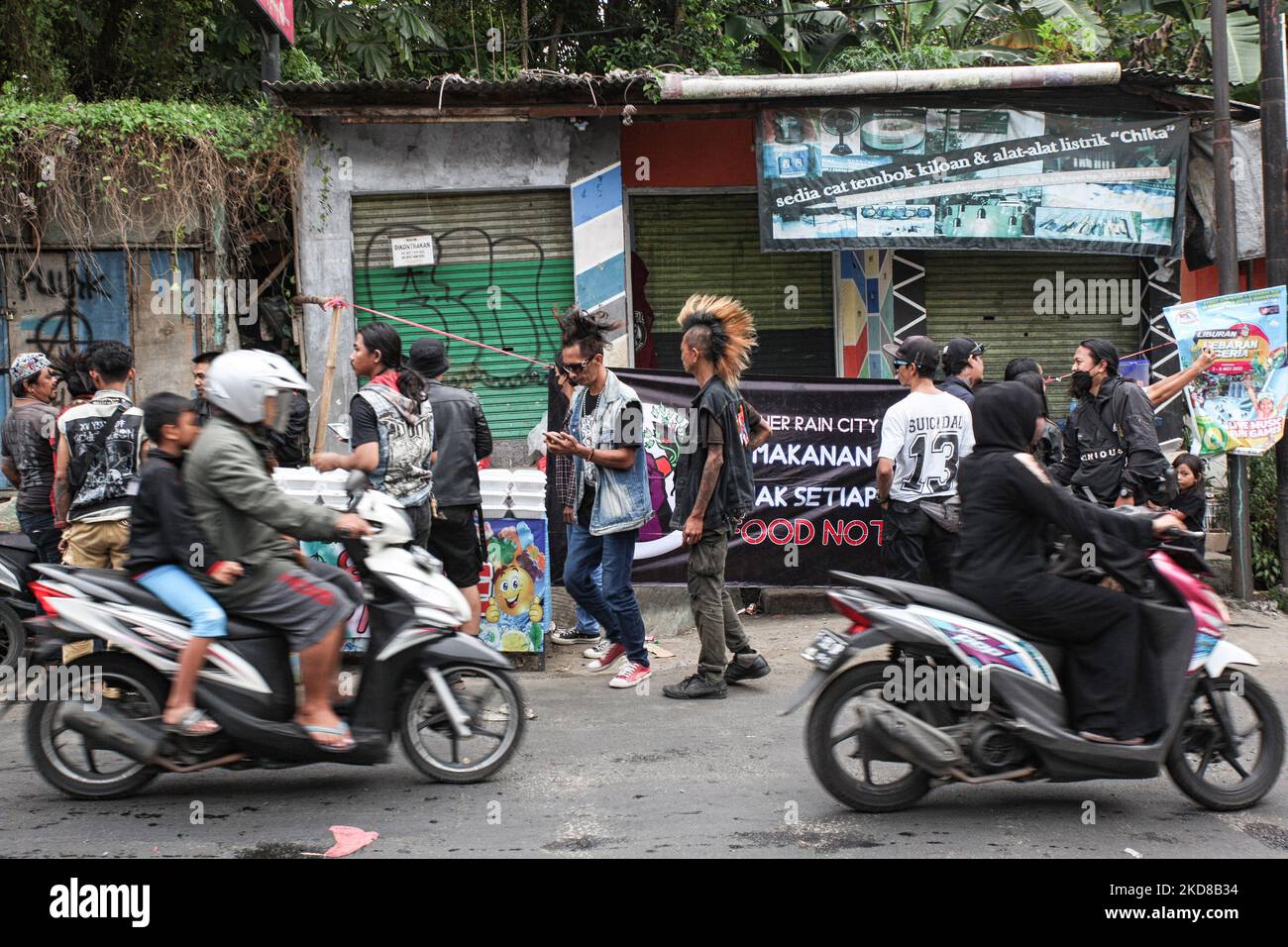 Indonesian street musicians in punk outfits distribute food boxes of ...