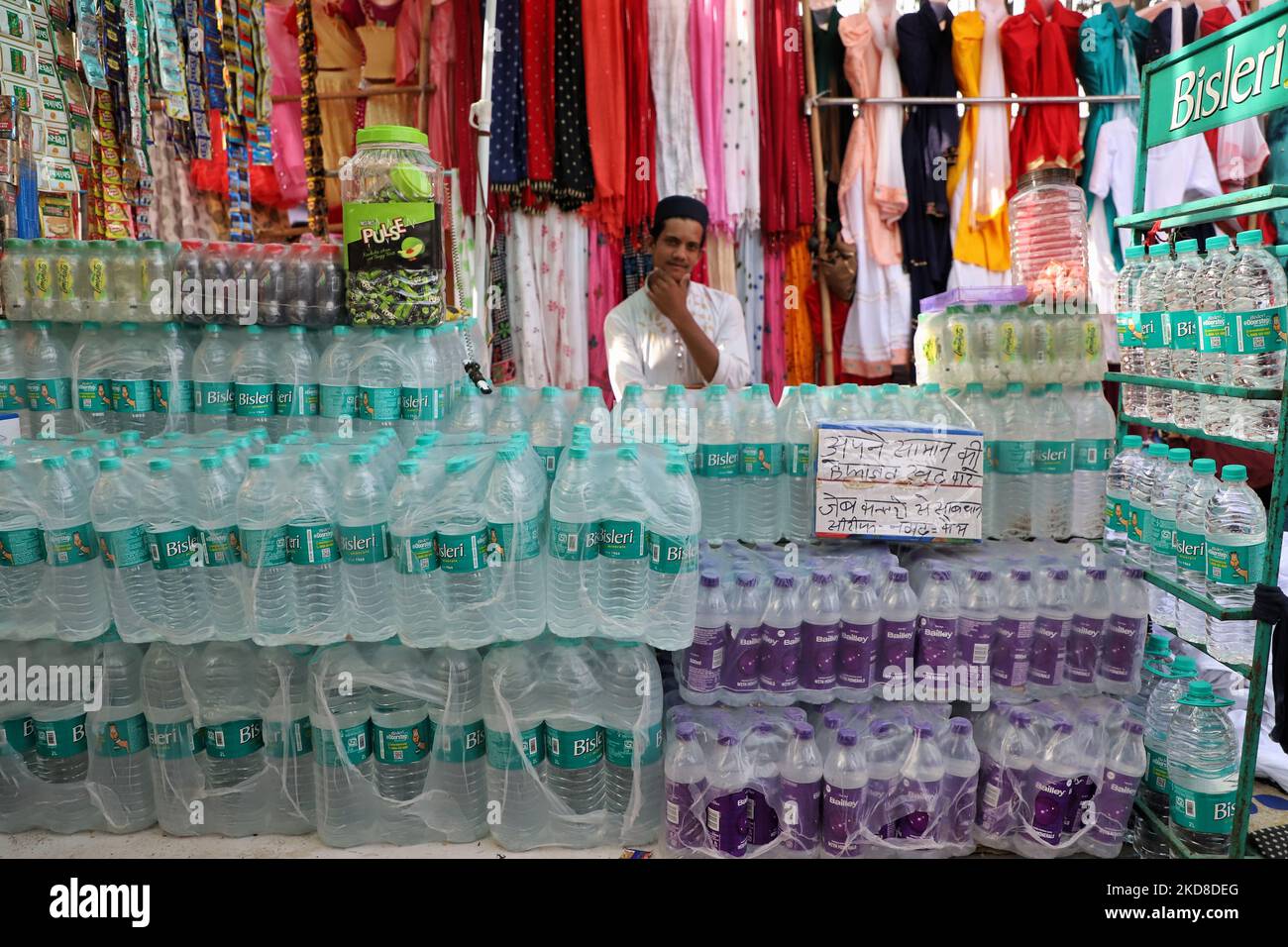 A boy selling water bottles waits for the customers on a hot summer day ...